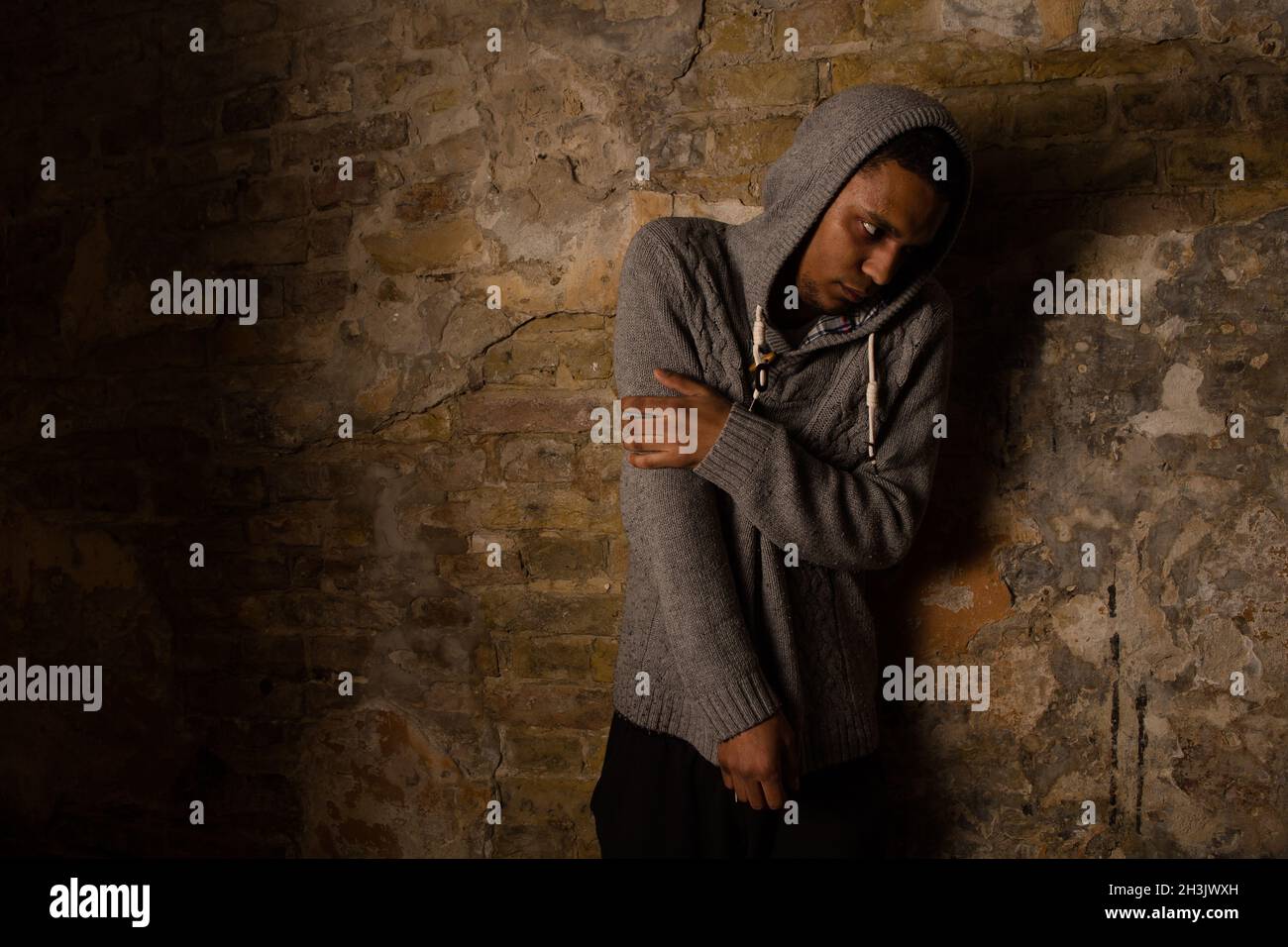 Drug addict posing near brick wall Stock Photo - Alamy