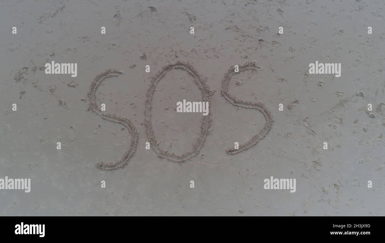 Top view photo of SOS written in sand on tropical beach Stock Photo - Alamy