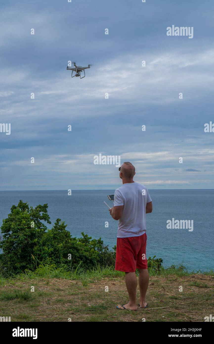 Man with drone camera taking photos of beautiful sea Stock Photo - Alamy