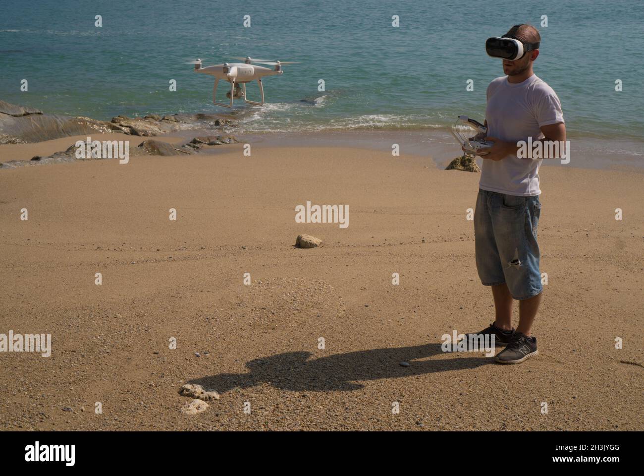 Man with drone camera and virtual reality glasses taking photos and ...