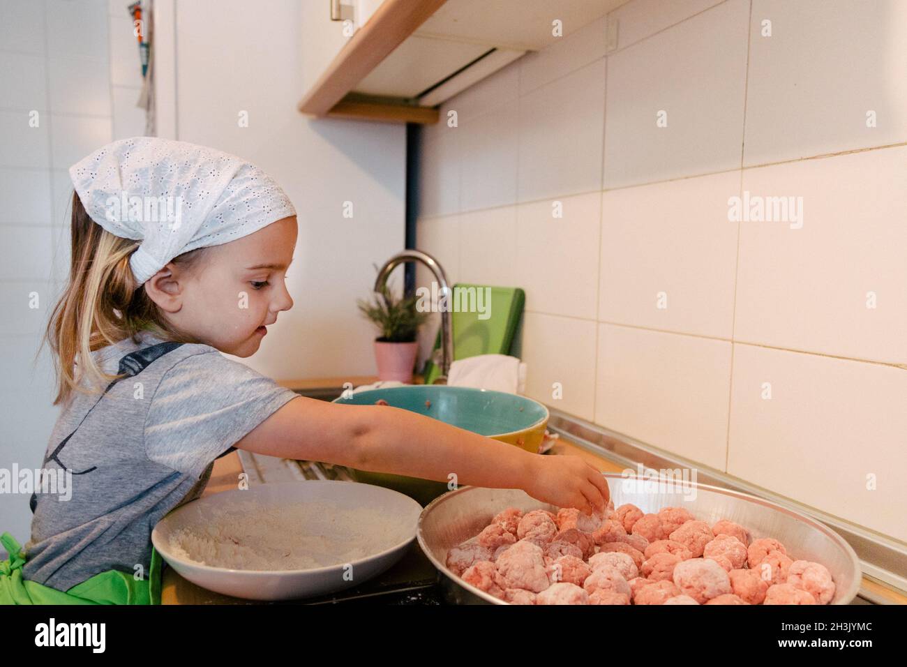 Little Girl making meat balls in the kitchen Stock Photo - Alamy