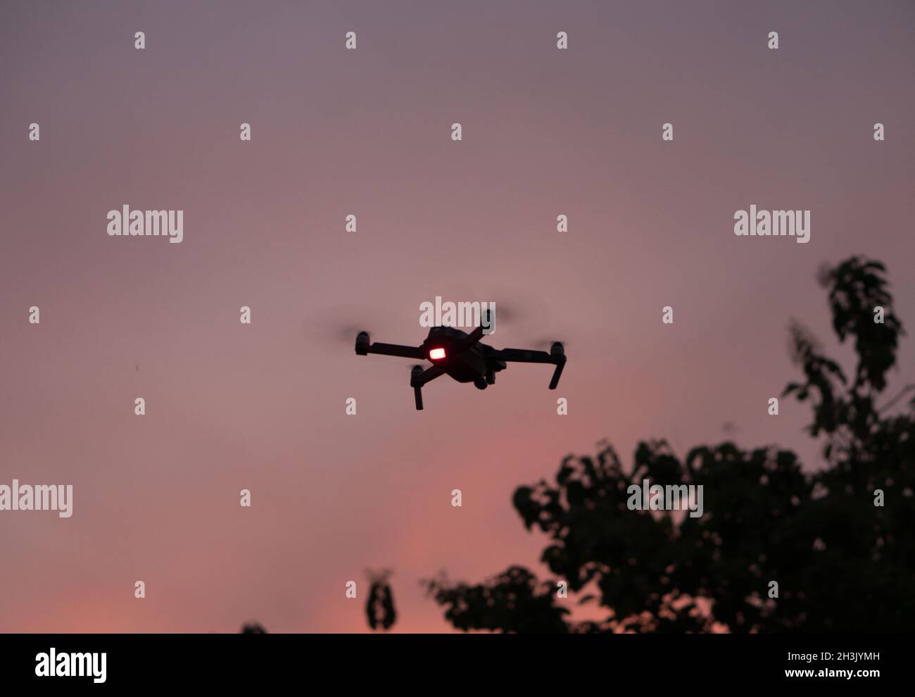 Flying drone against beautiful sunset sky Stock Photo - Alamy