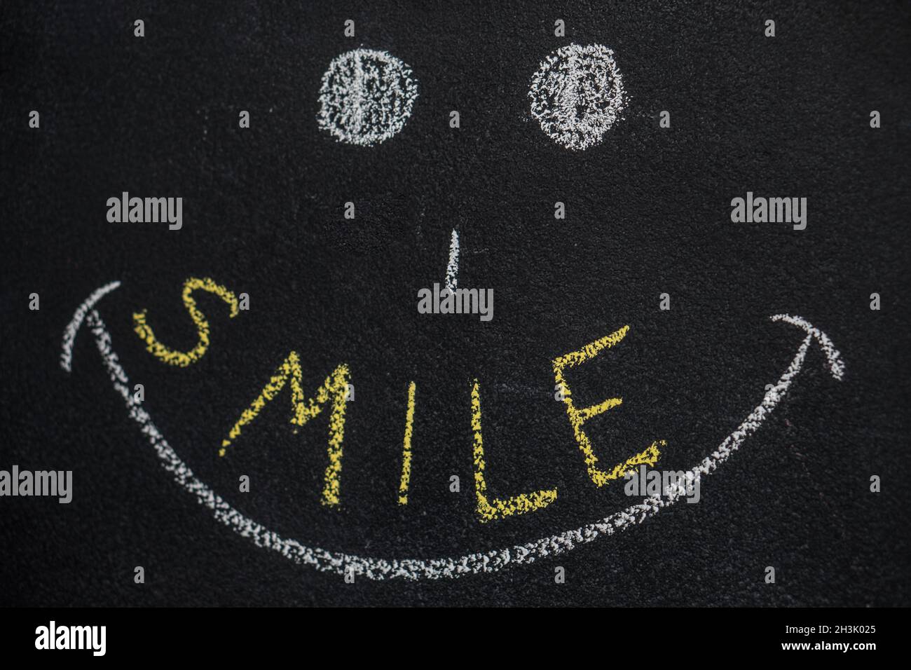 Happy cartoon face with smile word on blackboard Stock Photo - Alamy