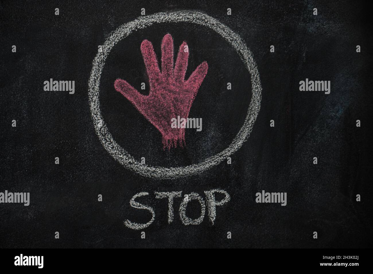 Red hand shape and stop word in the circle on black chalkboard Stock ...