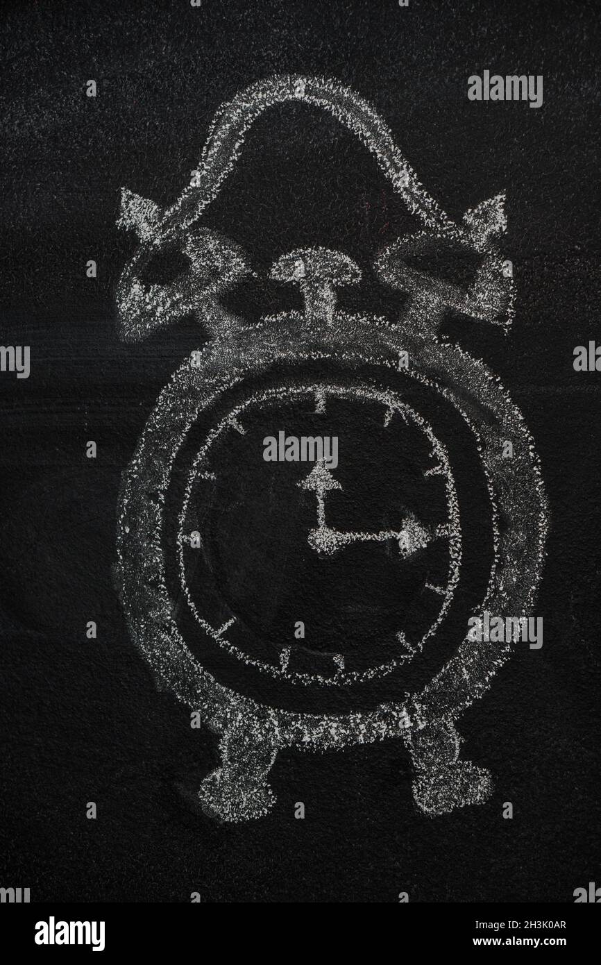 School alarm clock on black chalkboard Stock Photo - Alamy