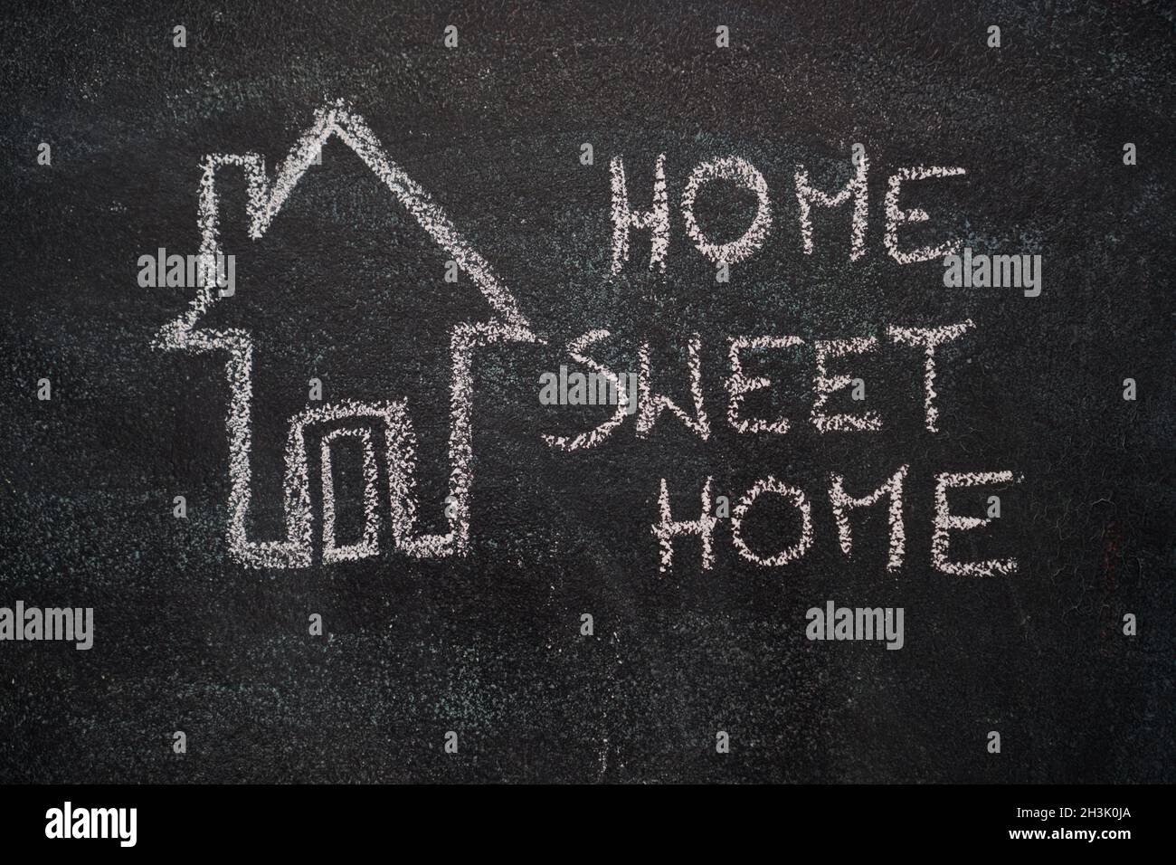 House with home sweet home writing on black chalkboard Stock Photo - Alamy