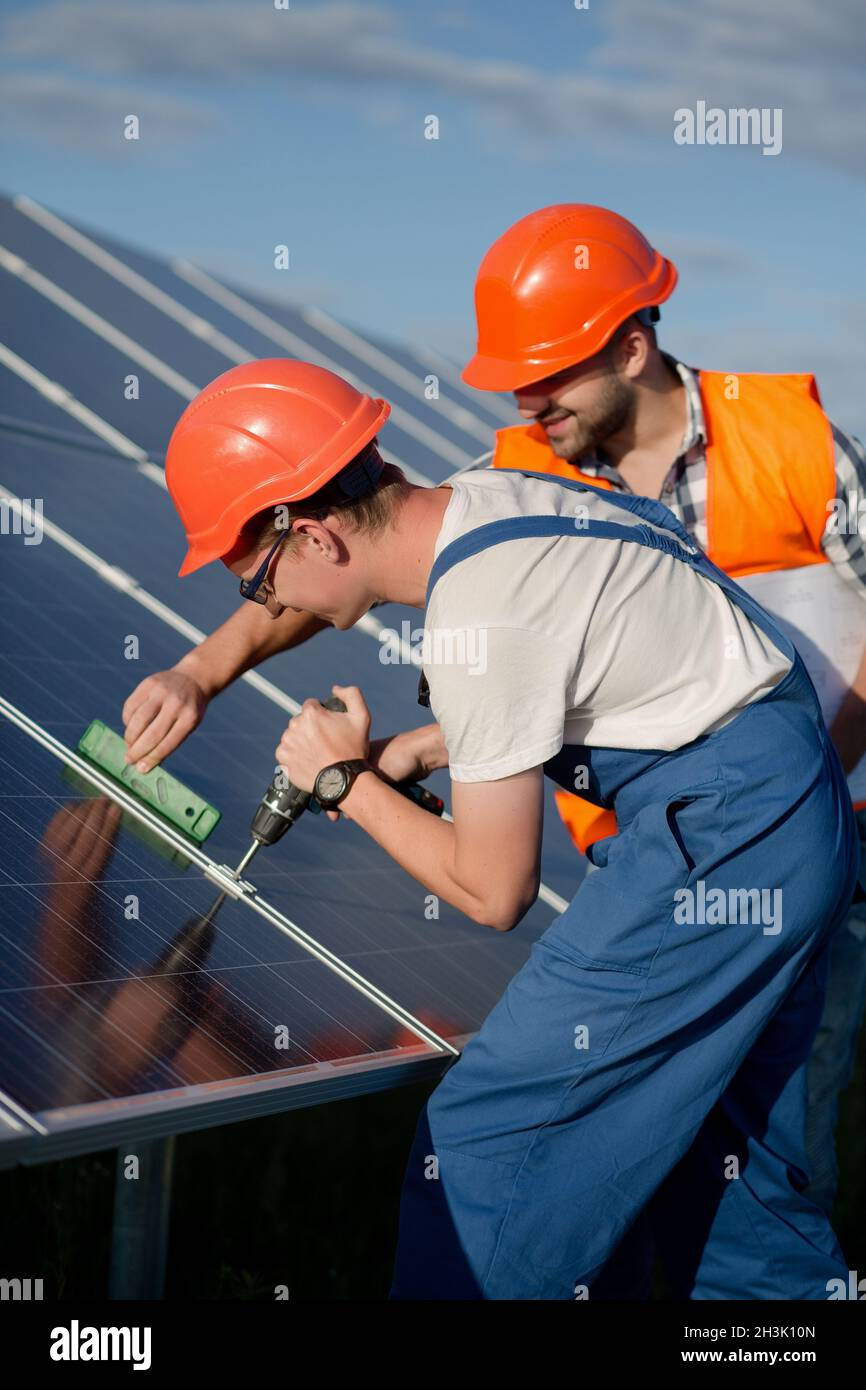 Technicians installing photovoltaic panels at solar power station Stock ...