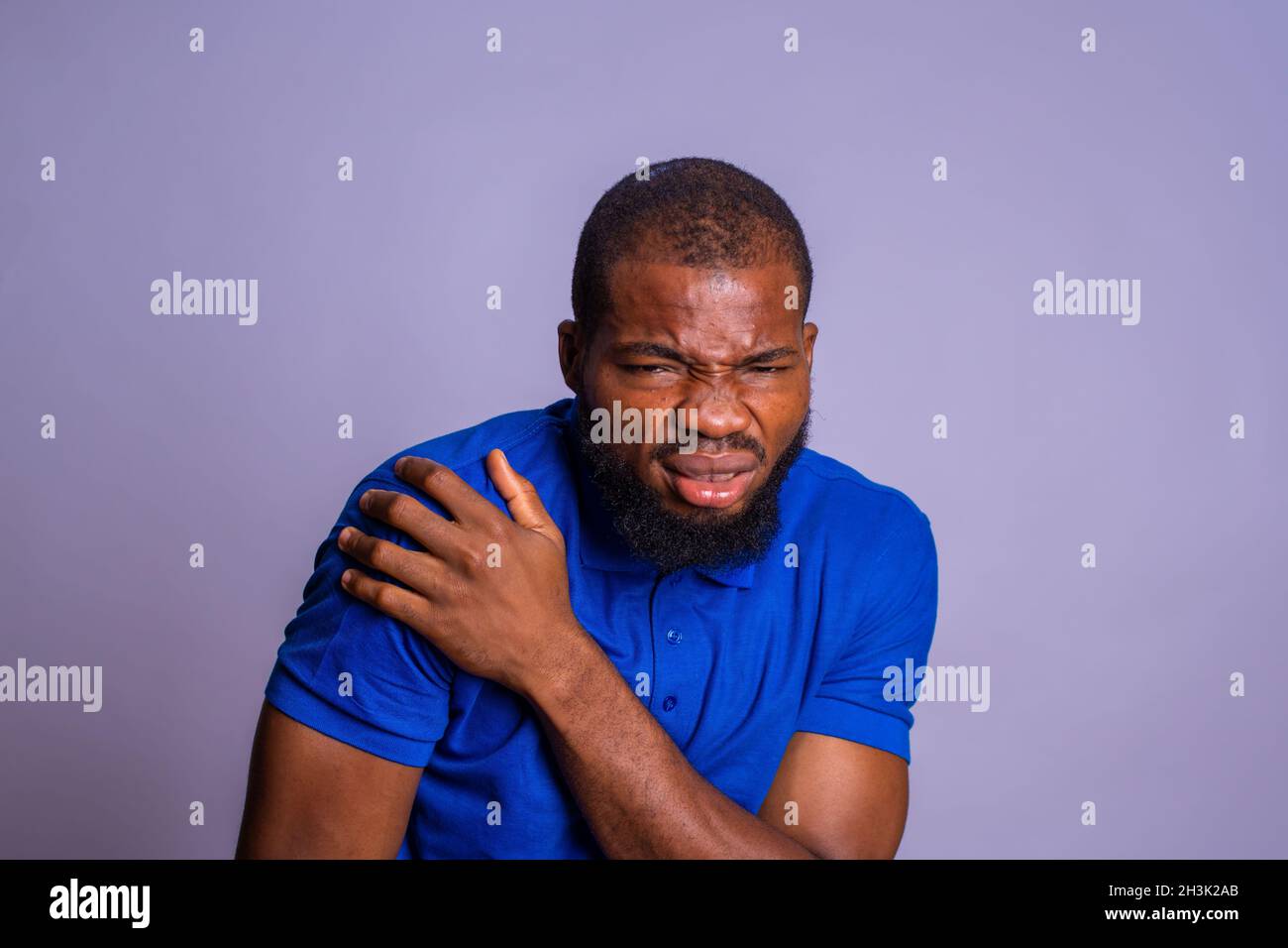black man holding feeling discomfort Stock Photo - Alamy