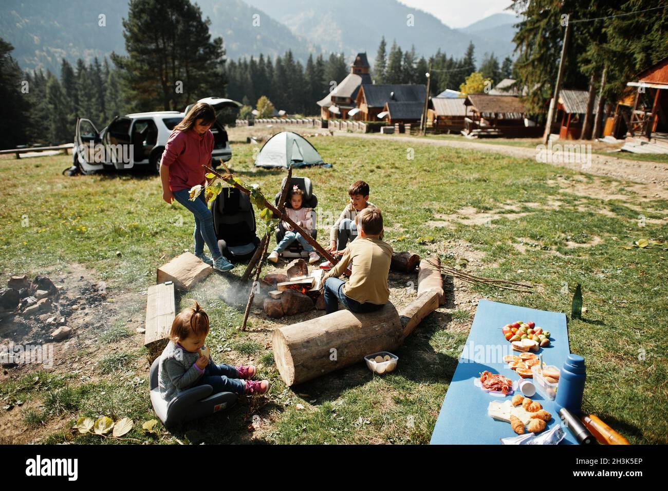 Family bonfire in mountain. Mother with four kids camping. Autumn hike ...