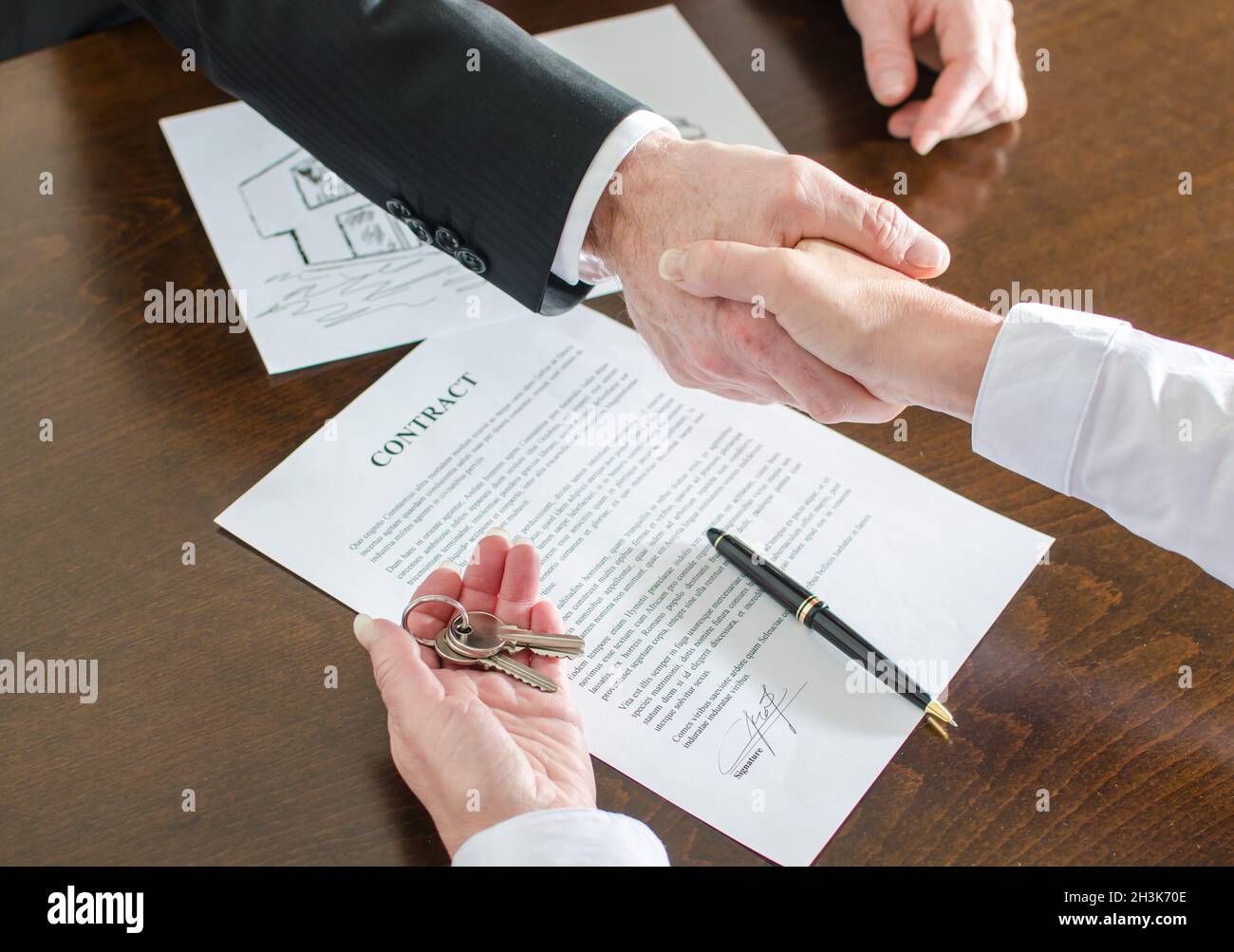 Estate agent shaking hands with his customer after delivering the house ...