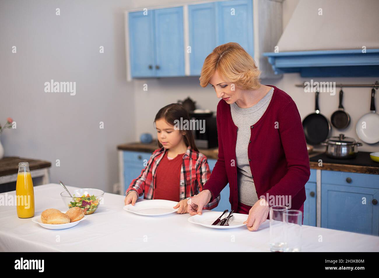 Grandmother and granddaughter lay the table Stock Photo - Alamy