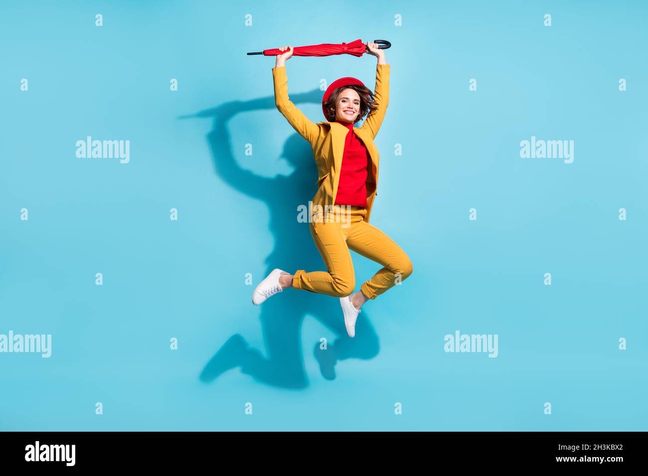 Full Length Body Size View Of Attractive Cheerful Girl Jumping Holding