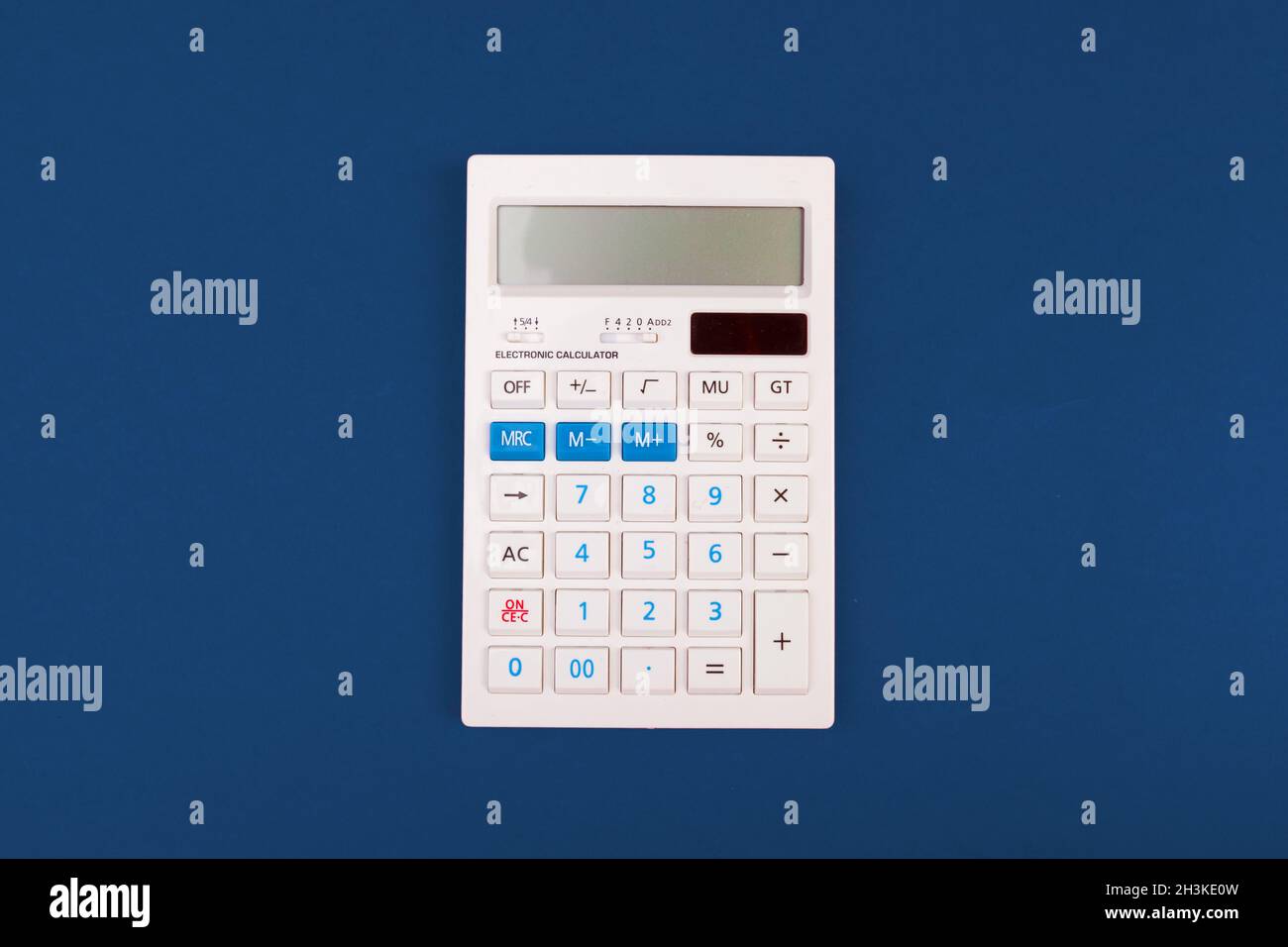 Top view of a calculator on a classic blue background Stock Photo - Alamy