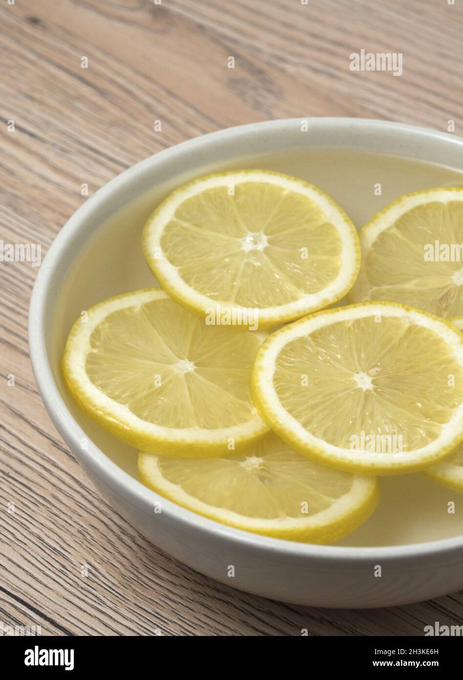 Lemon slices in a bowl with water. Close up view Stock Photo - Alamy