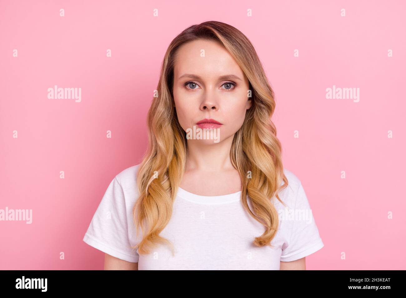 Photo portrait serious woman wearing white t-shirt isolated pastel pink ...