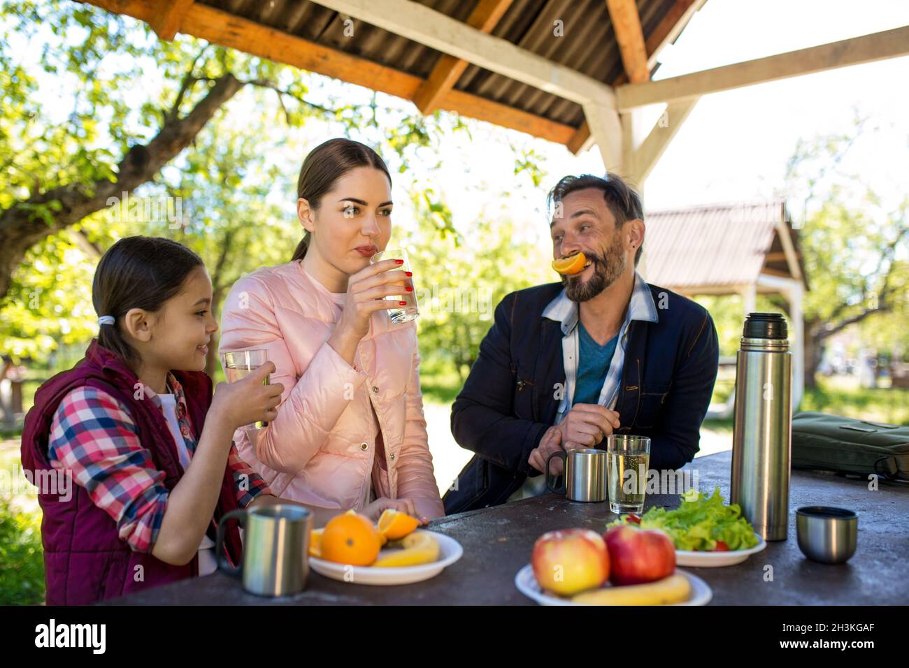 Happy family enjoy snack in park pavillion Stock Photo - Alamy