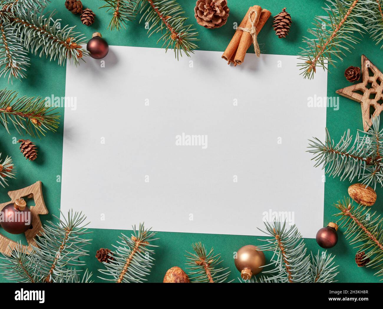 Fir tree branches and blank paper on green background Stock Photo - Alamy