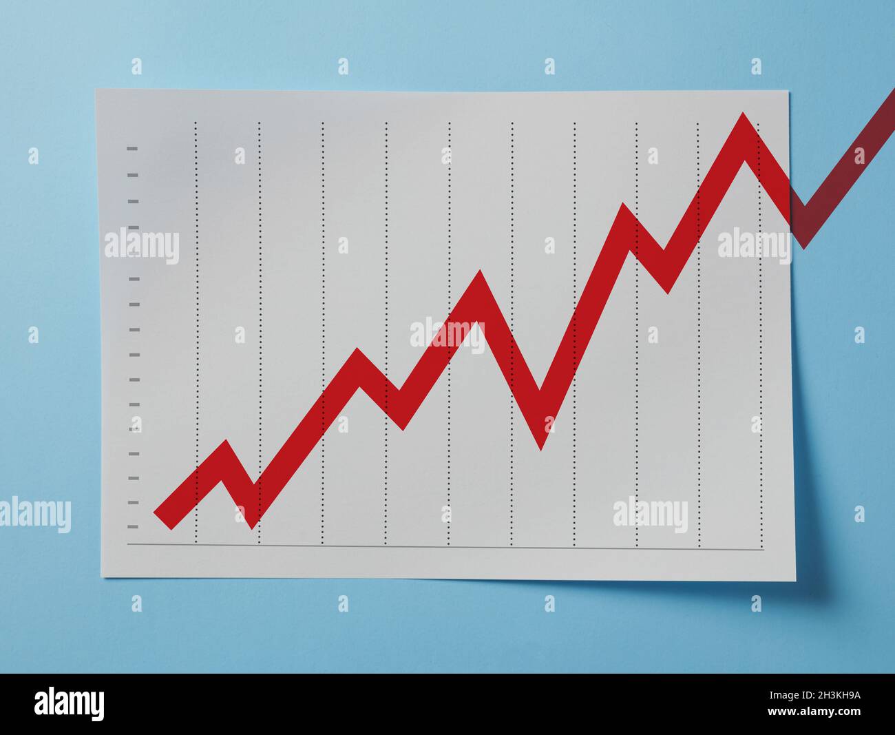 Growing chart on A4 page on blue background Stock Photo - Alamy