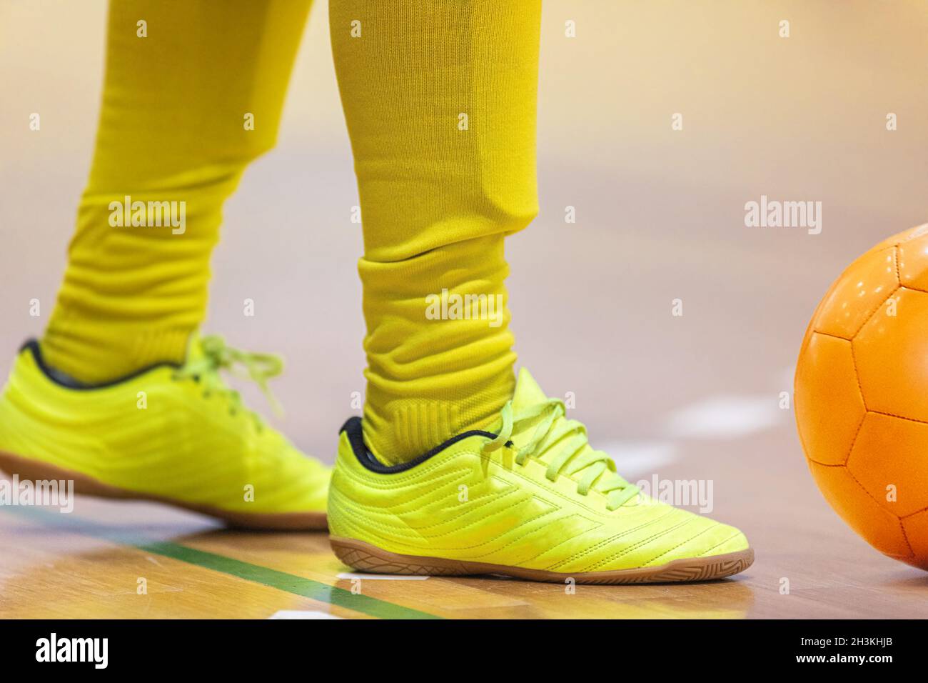 Boy in Soccer Clothes with Ornage Futsal Ball. Kid on indoor soccer ...