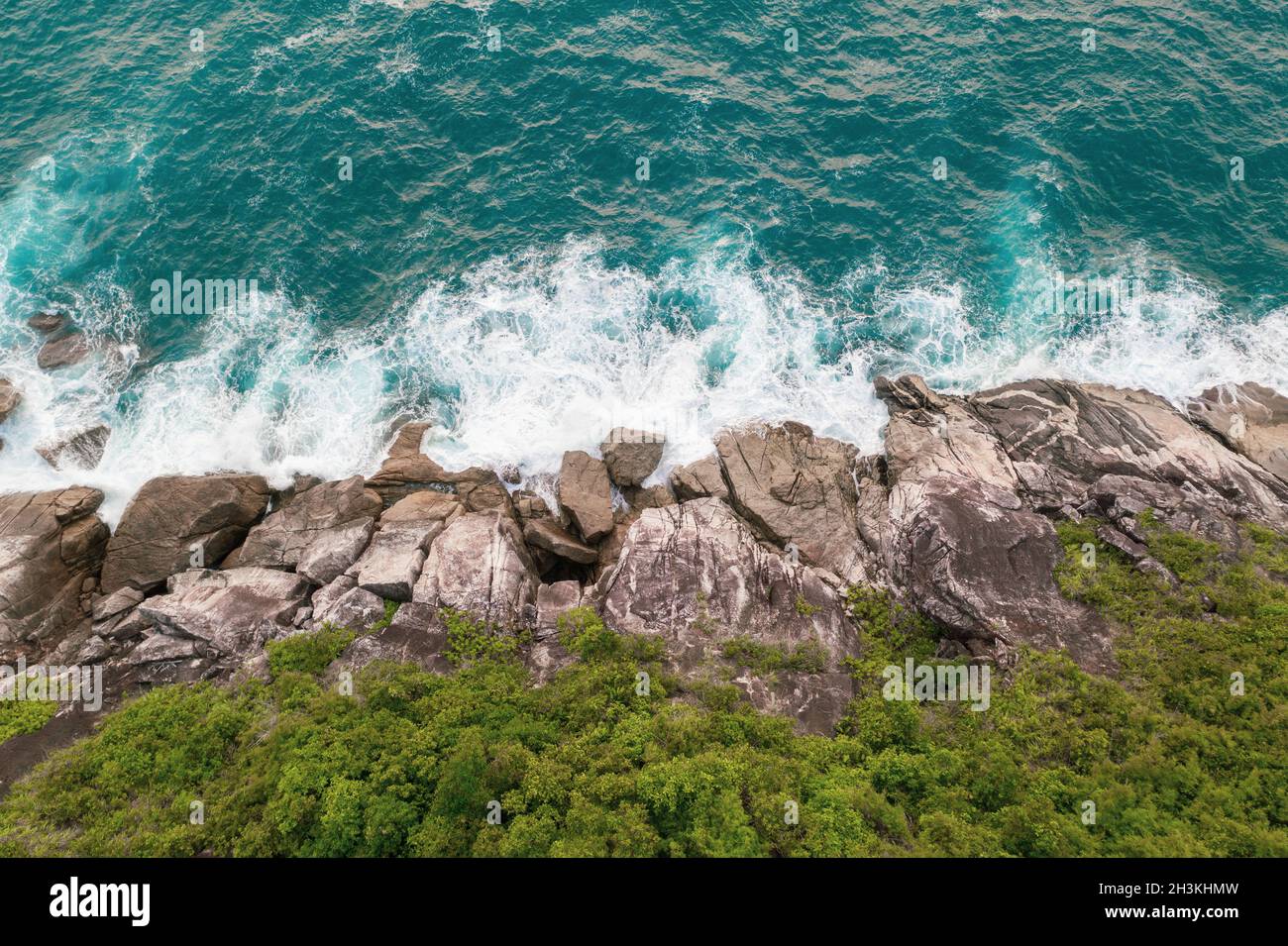 Aerial view of beautiful ocean waves and rocky coast with greenery ...