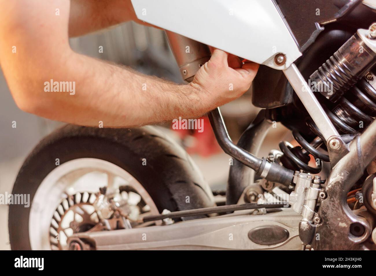 Mechanic close up repairing motorbike in repair garage Stock Photo - Alamy
