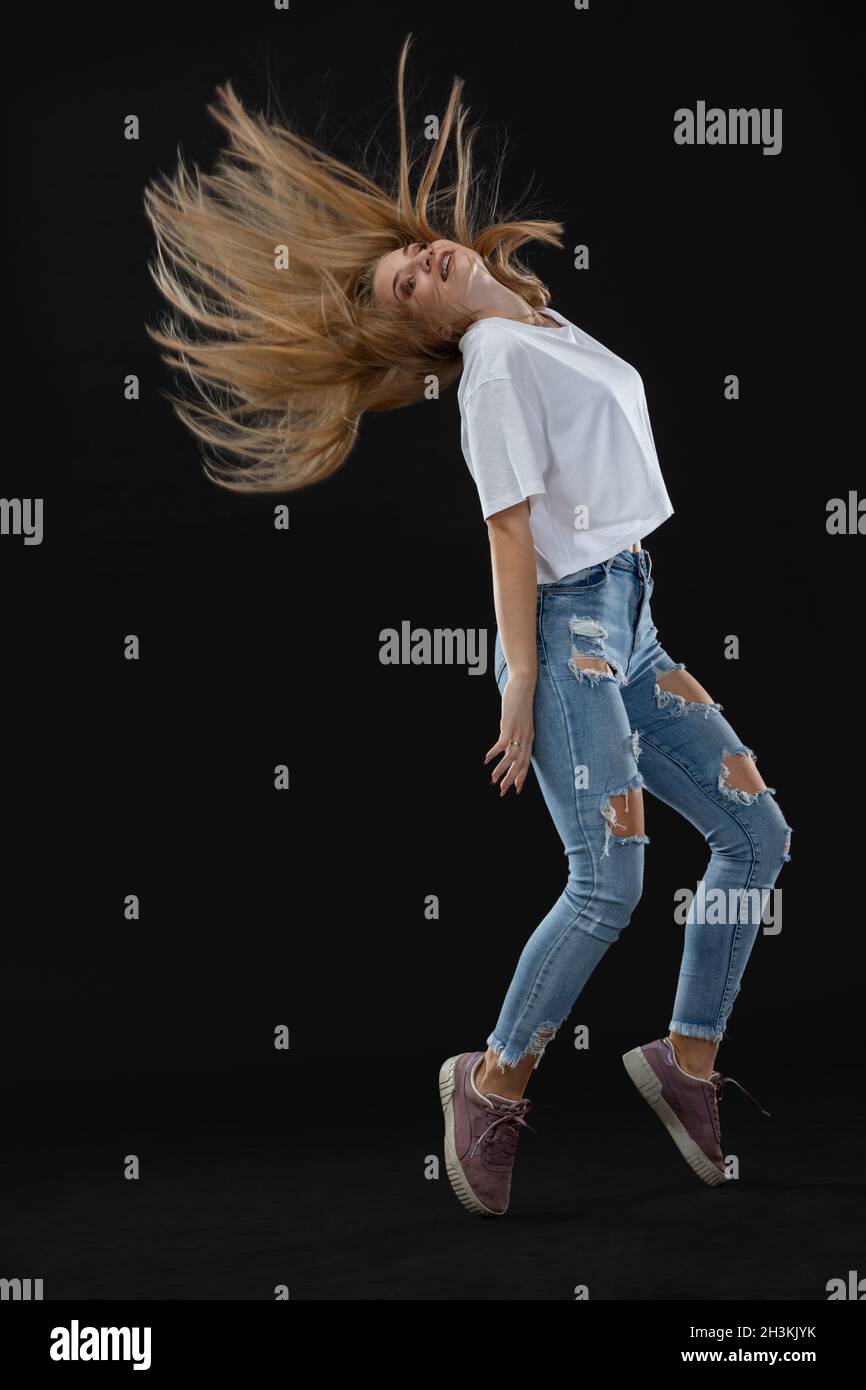 A young dancer standing on tiptoe leans back and throws her voices up ...