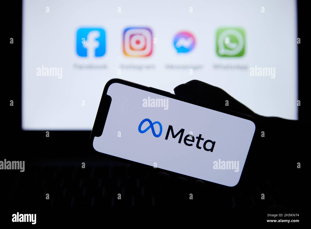 The logo of Meta is seen on a smartphone and the logos of Facebook ...