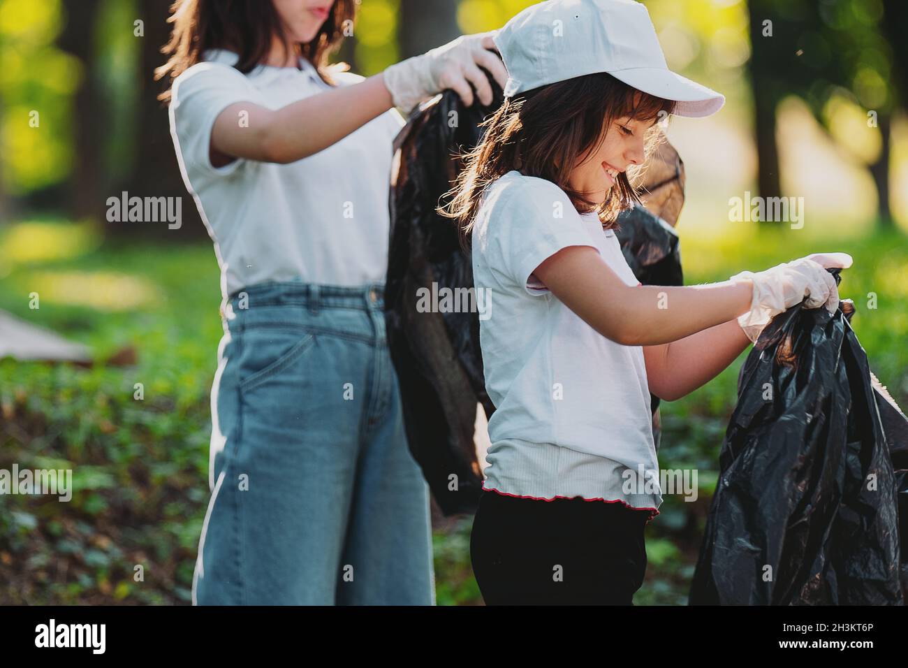 Side view photo of two happy girls participate in voluntary work in ...