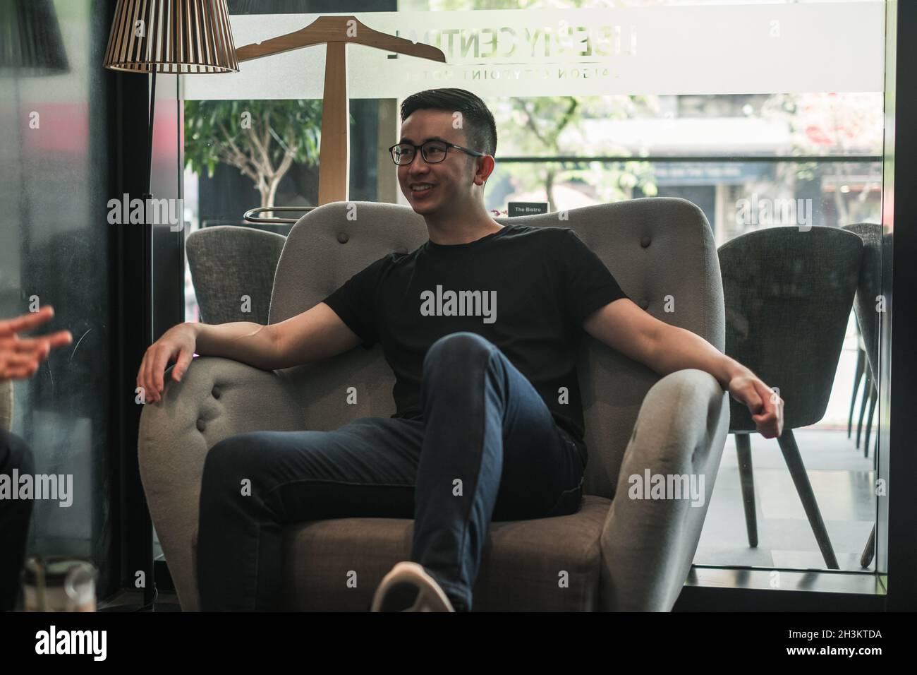 Asian young handsome man sitting in coffee shop, talking and smiling ...