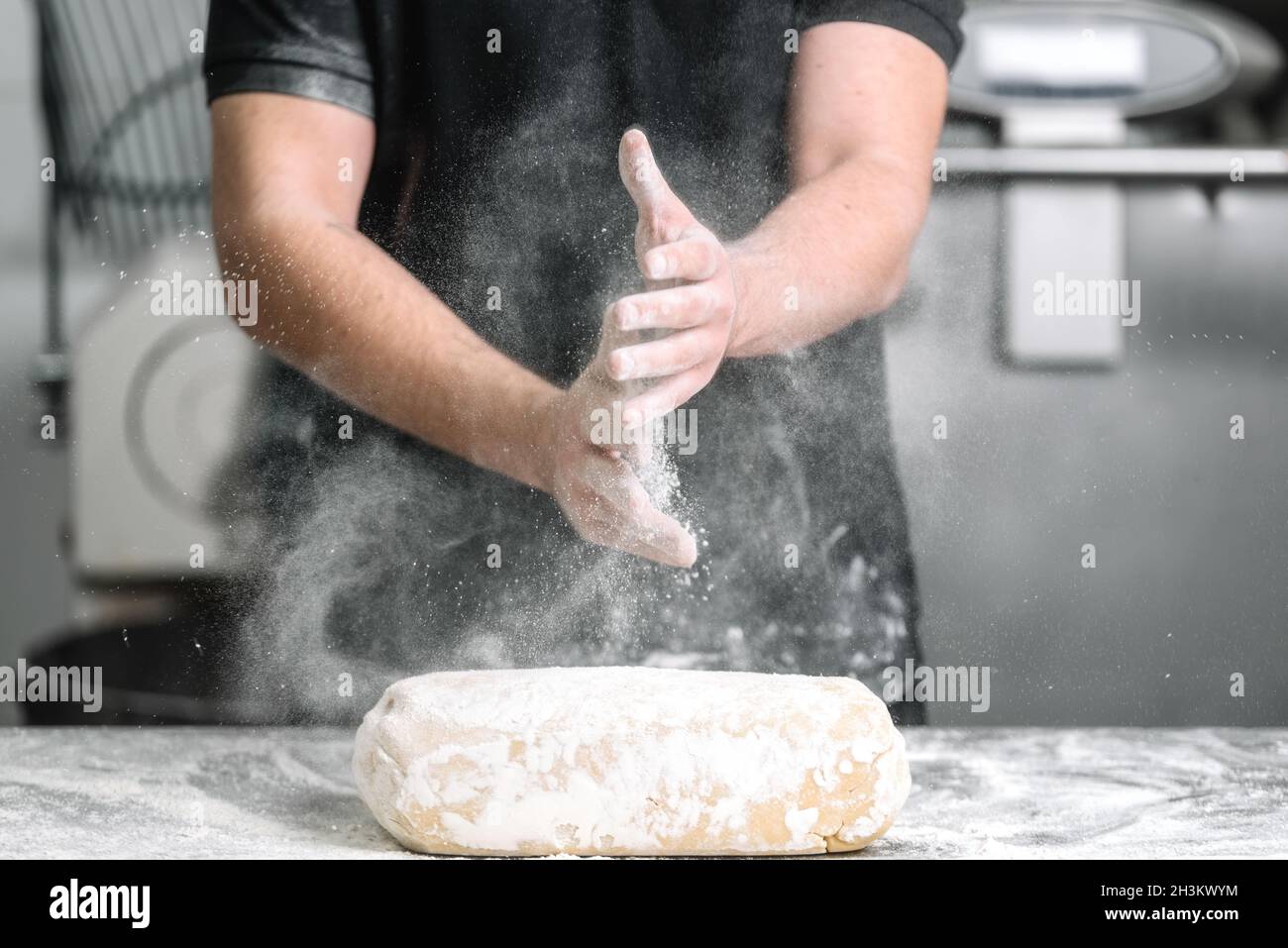 Baker claping hands with flour in restaurant kitchen Stock Photo - Alamy