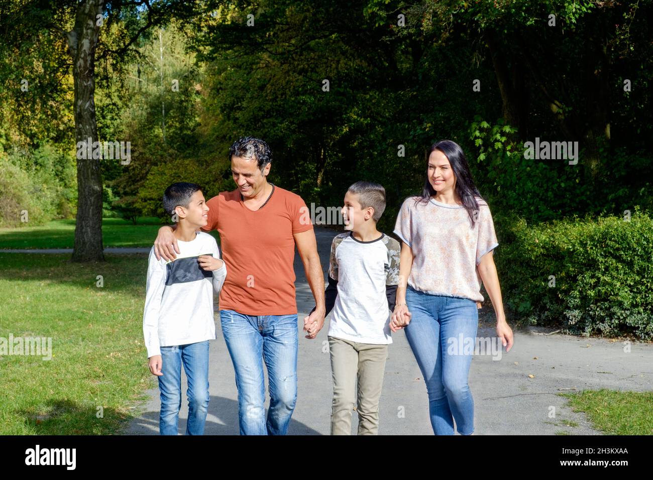 Walking family with two children in park Stock Photo - Alamy