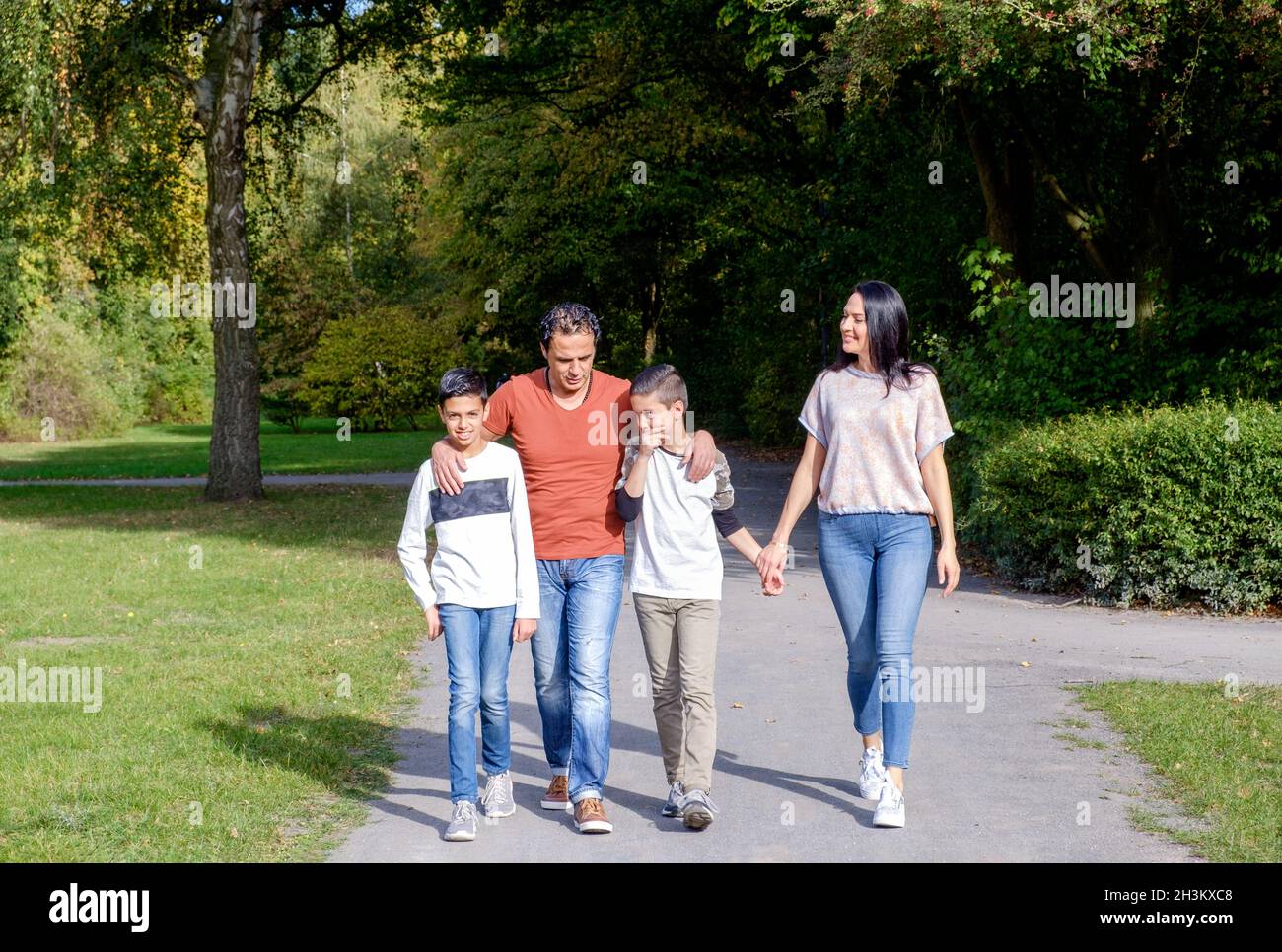 Walking family with two children in park Stock Photo - Alamy