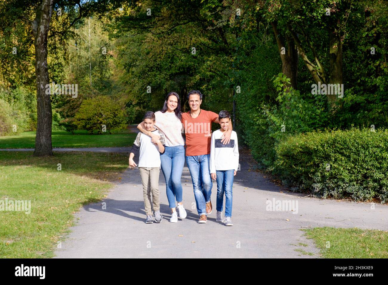 Walking family with two children in park Stock Photo - Alamy
