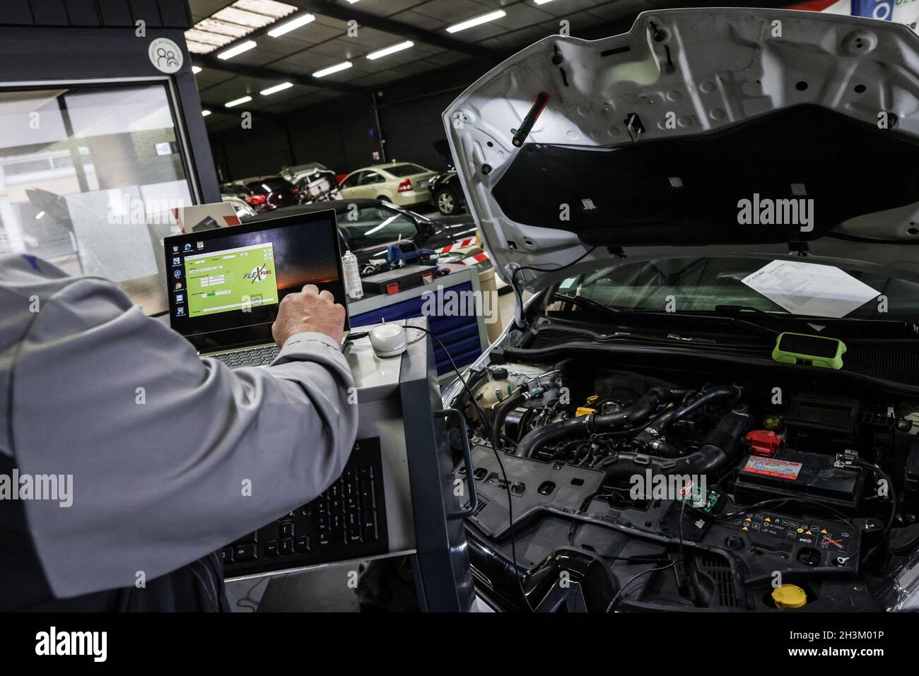 A garage owner installs a FlexFuel kit for switching to E-85 fuel ...