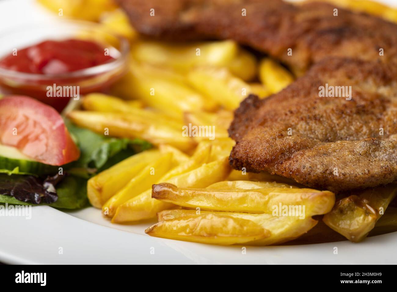 Wiener Schnitzel with French fries on the plate Stock Photo - Alamy