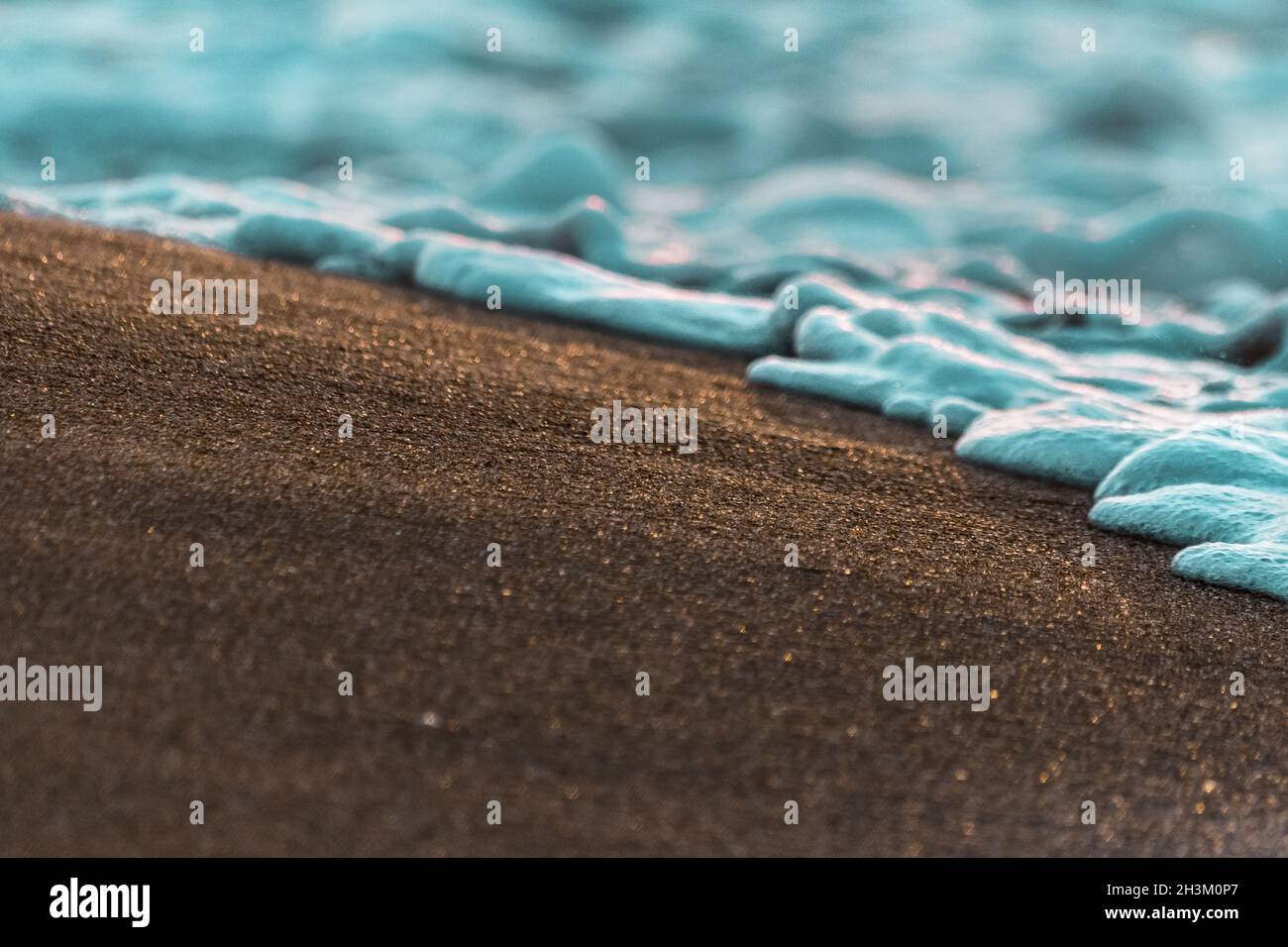 Blue wave on beautiful sand Stock Photo - Alamy