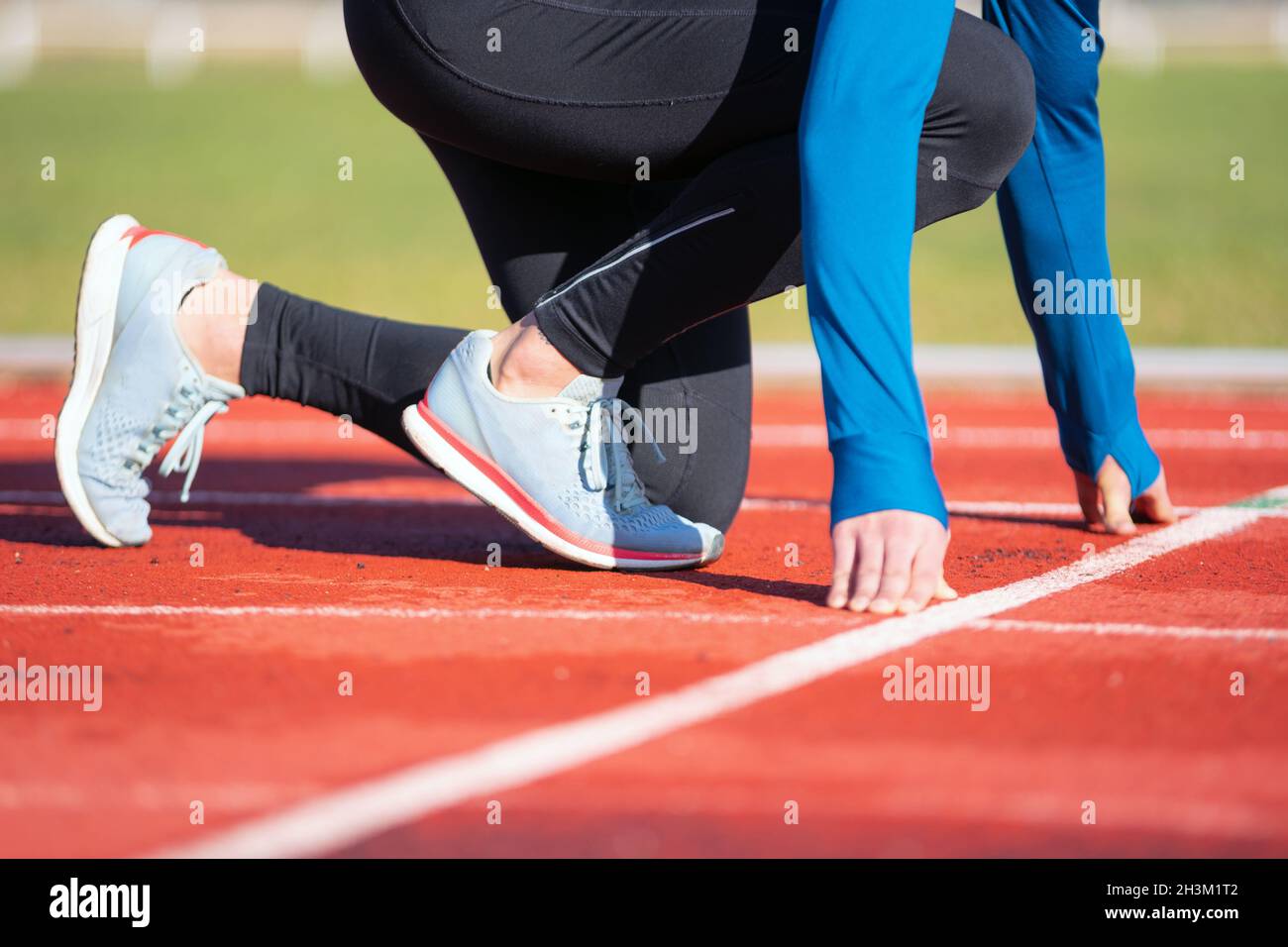 Man athlete on the starting line of a running track at the stadium ...