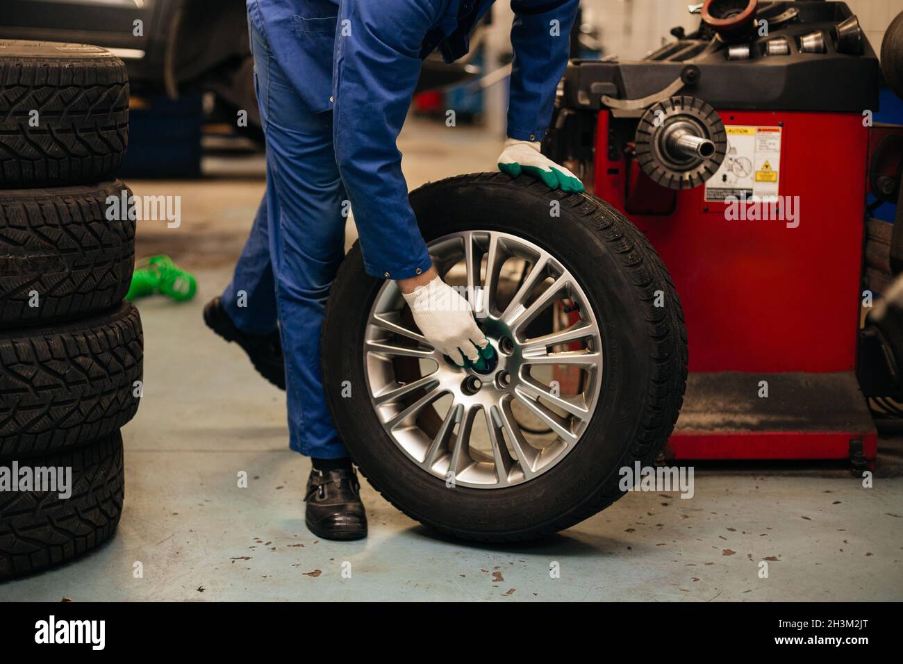 Auto mechanic balances the car wheel on the wheel balancer Stock Photo ...