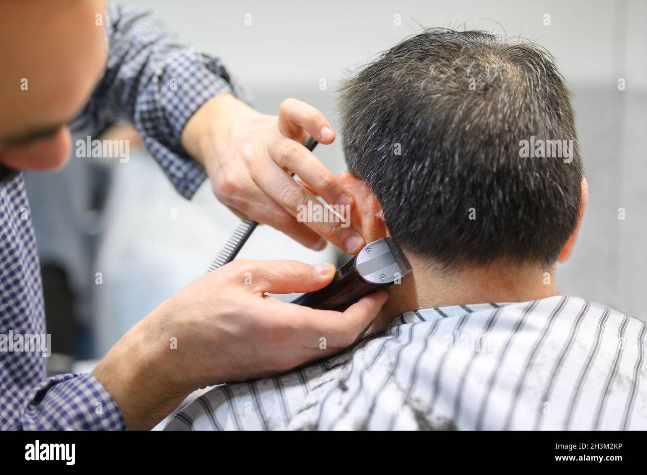 Barber trimming hair of old man at barber shop Stock Photo - Alamy