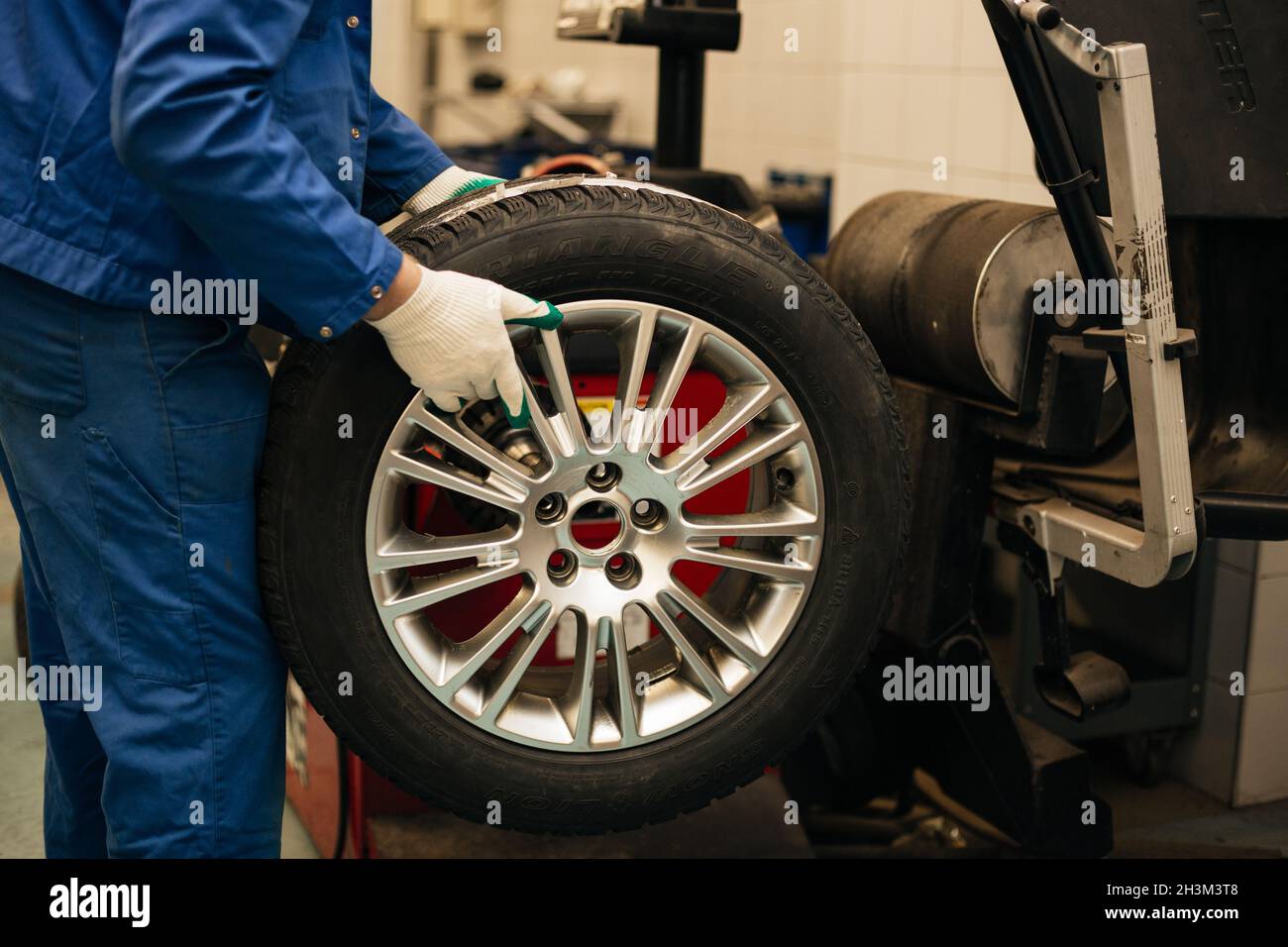 Auto mechanic balances the car wheel on the wheel balancer Stock Photo ...