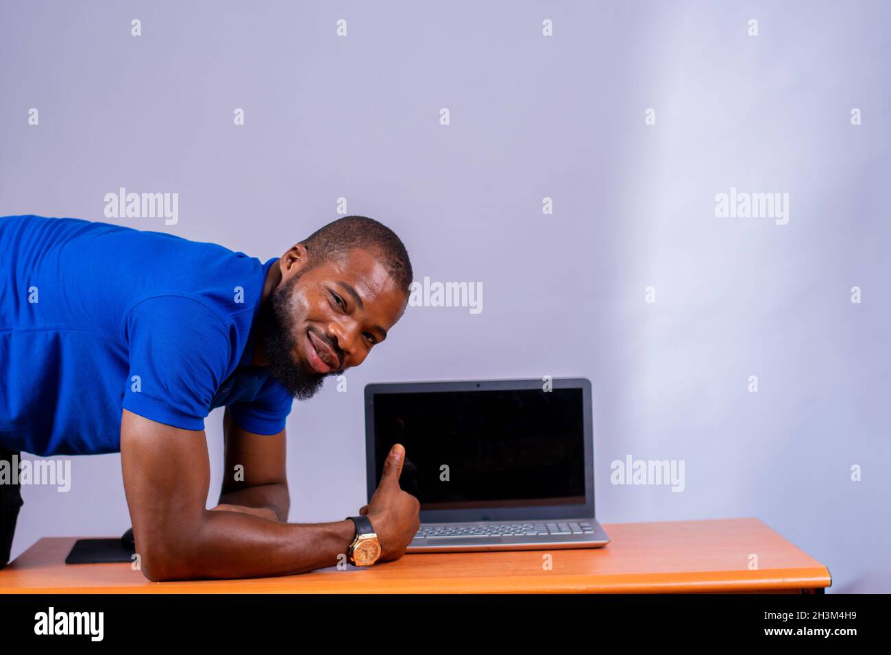 handsome young black man pointing to his laptop screen that is blank ...
