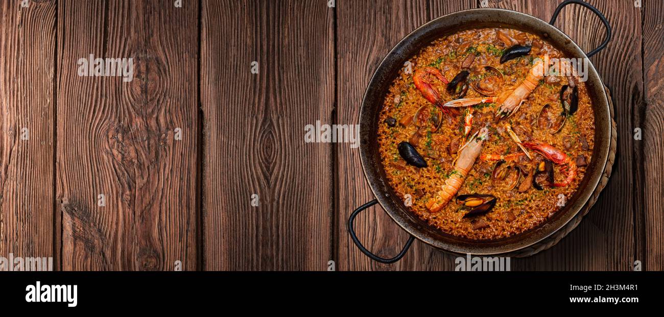 Seafood paella on rustic wood on banner format Stock Photo - Alamy