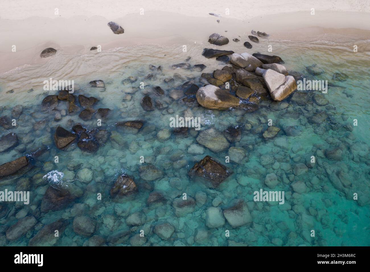 Aerial view of crystal clear turquoise sea water and rocks Stock Photo ...
