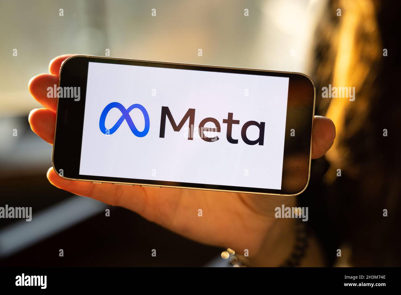 Meta logo on the iPhone. Woman holding smartphone with new facebook ...