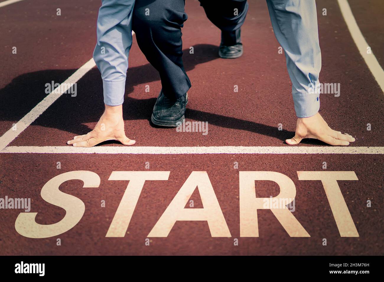 Business man waiting for start signal to run on competition running ...