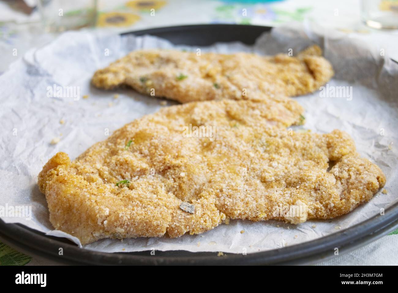 homemade breaded chicken cutlet in a crisp plate to be cooked in the ...