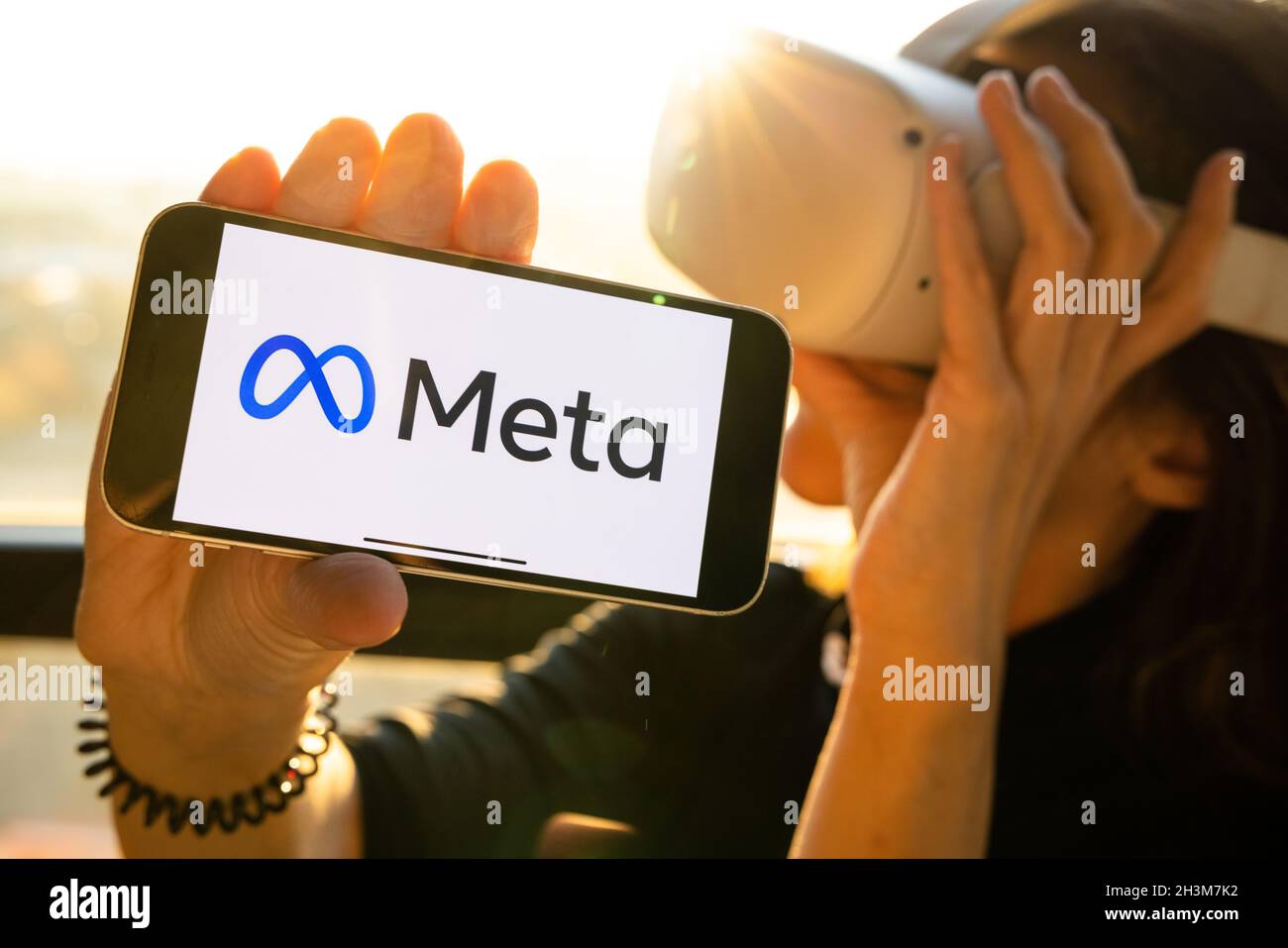 Meta logo on the iPhone, rebranding. Woman holding smartphone with new ...