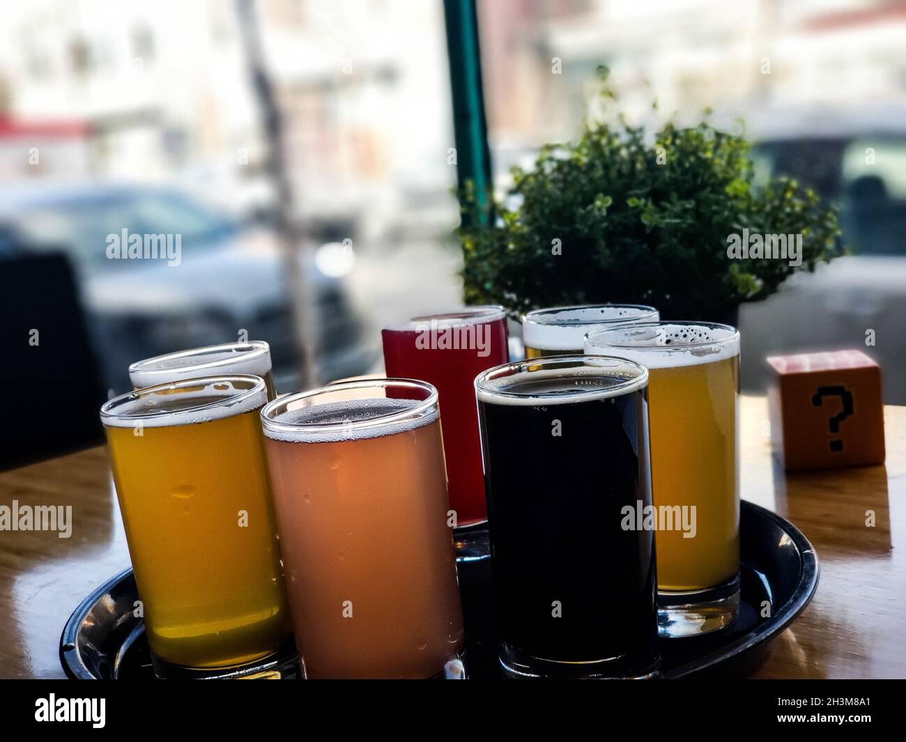 Closeup shot of different types of beers with glasses on a black tray ...