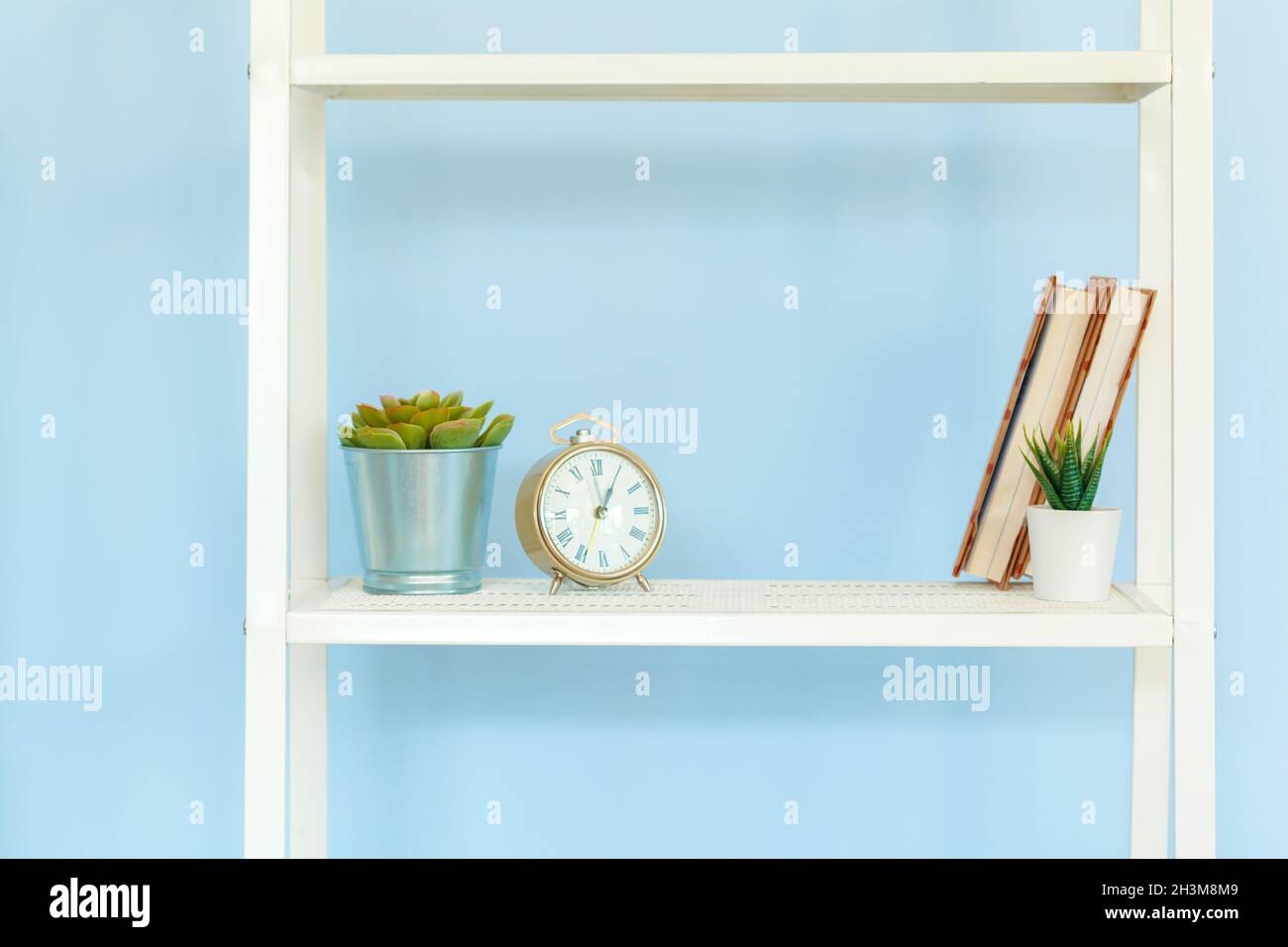 White metal rack with books against blue background Stock Photo - Alamy