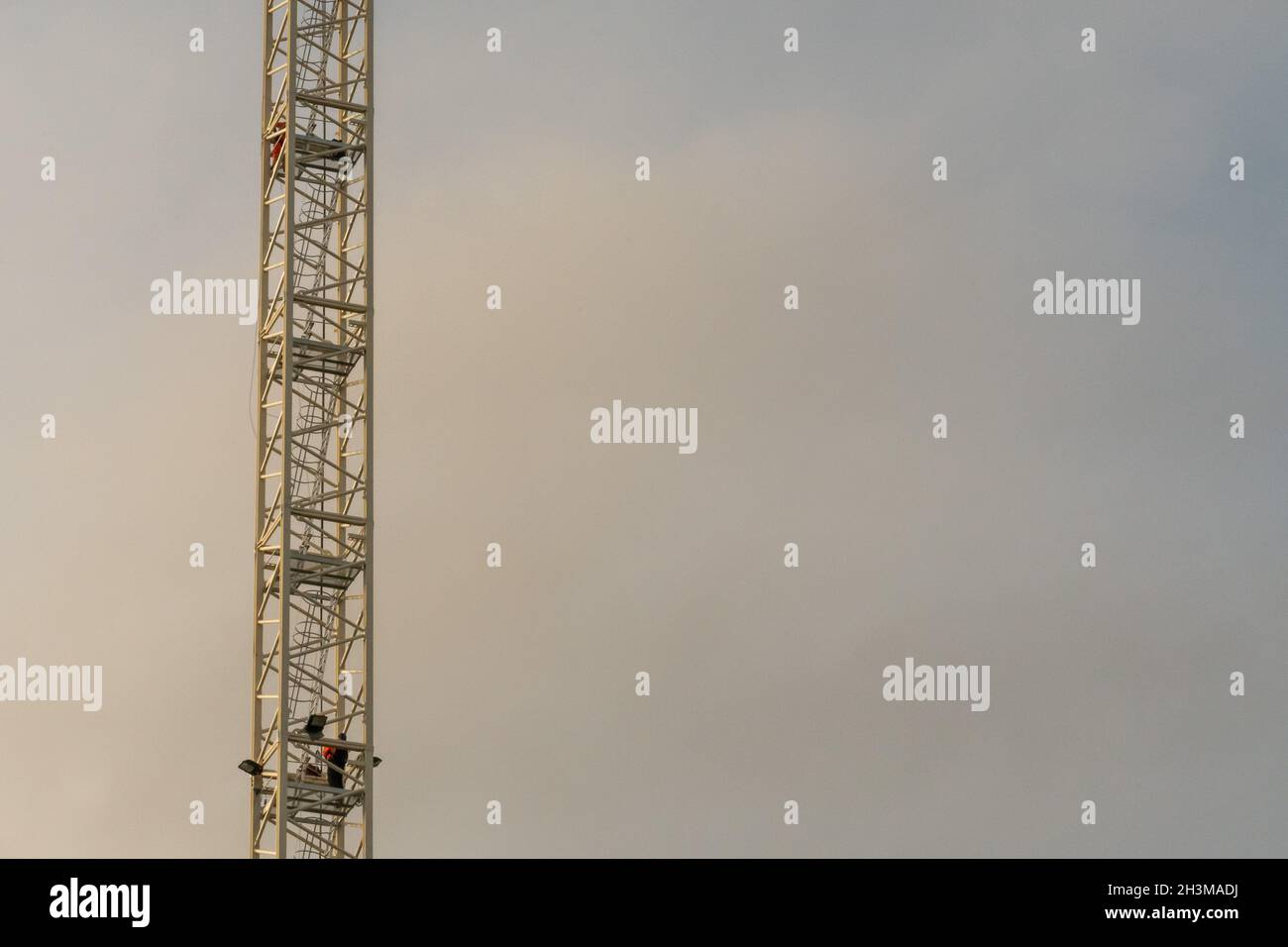 A construction worker descends the ladders of a tower crane Stock Photo ...